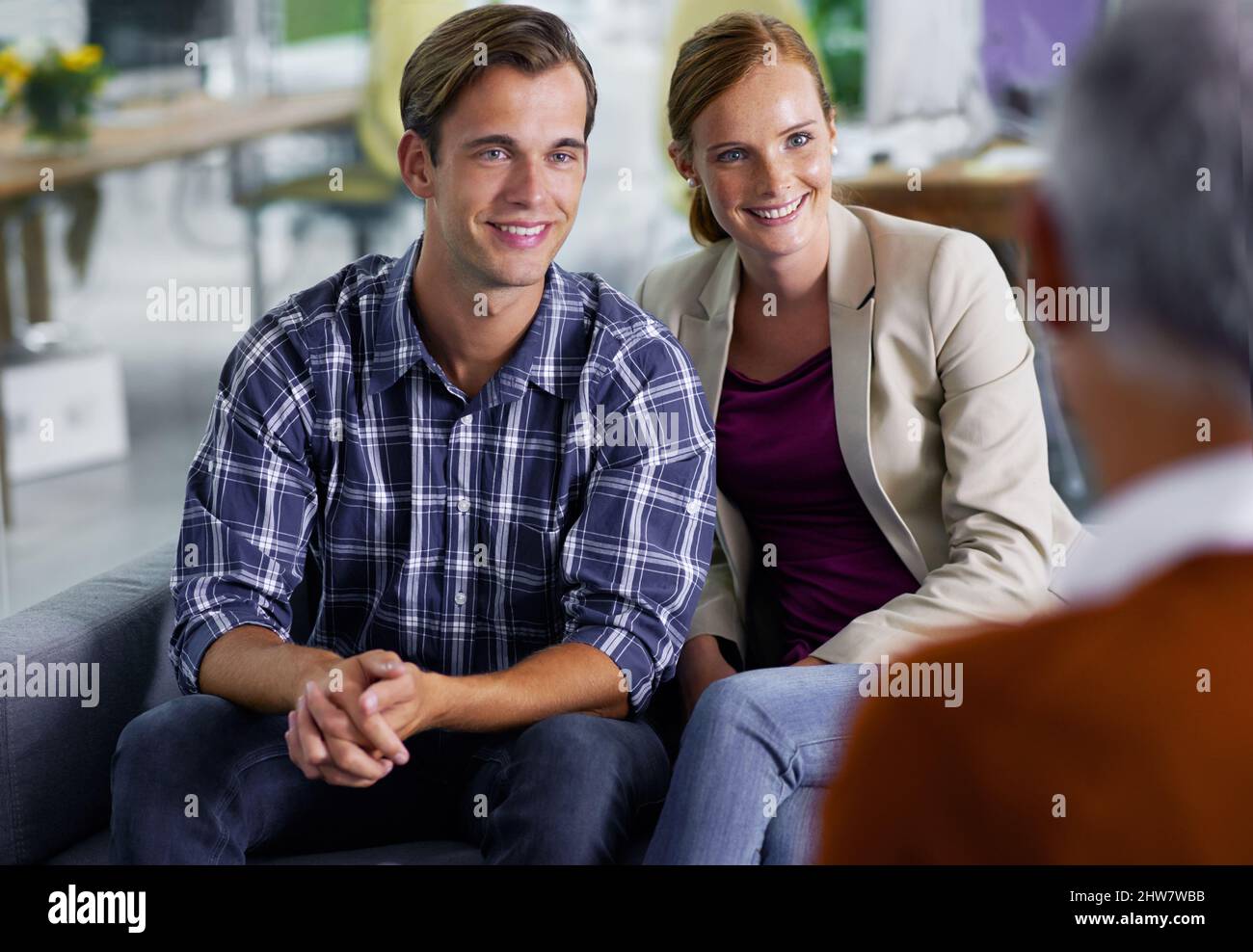 Putting their faith in their financial advisor. Smiling young couple ...