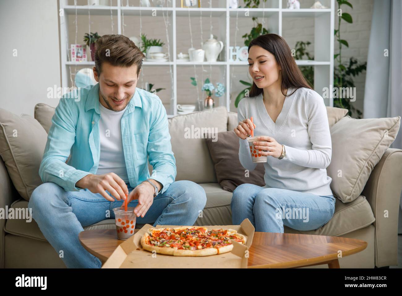Couple sharing pizza and eating Stock Photo - Alamy