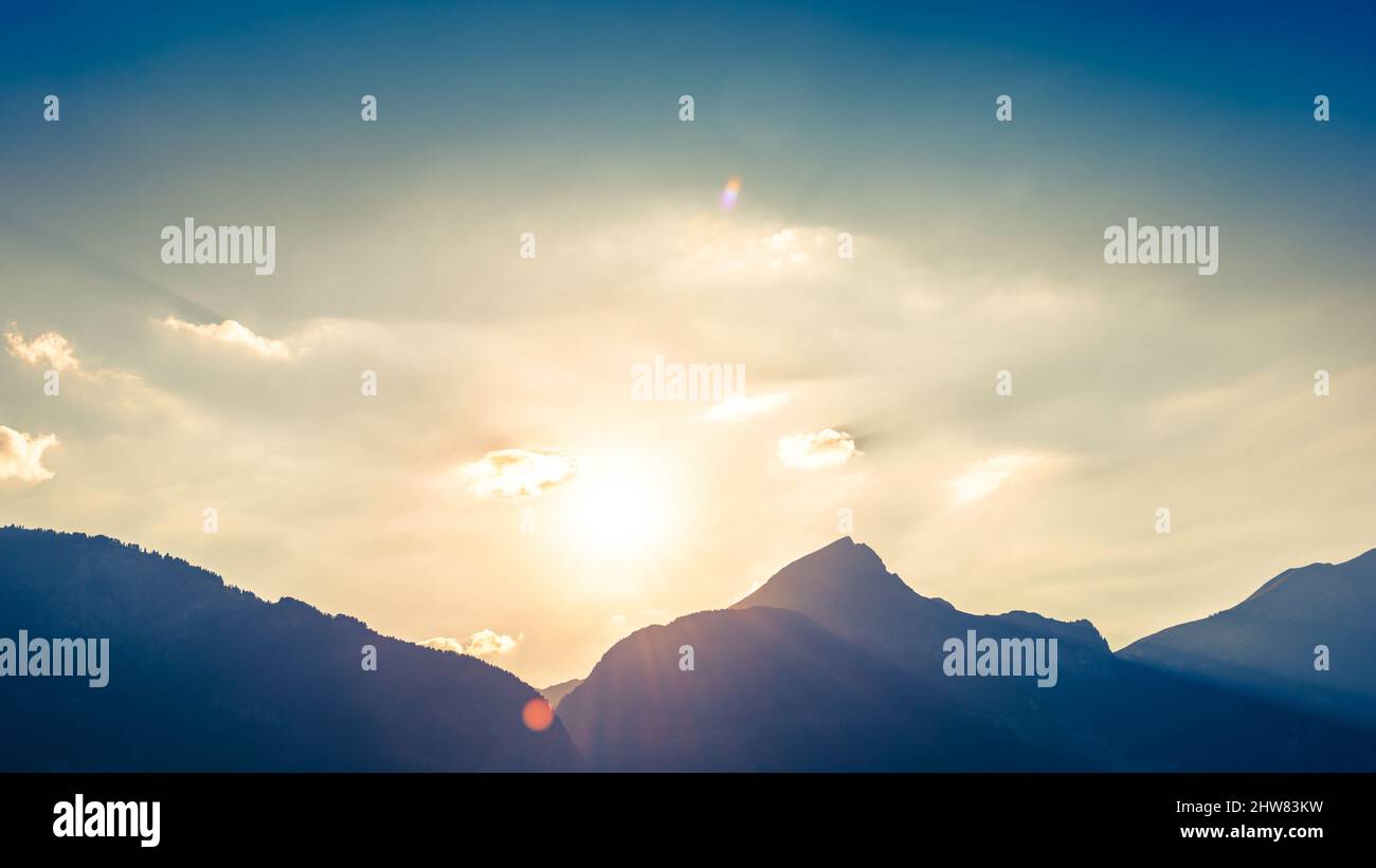 Natural background. Mountain peaks, sun. Toning Stock Photo - Alamy
