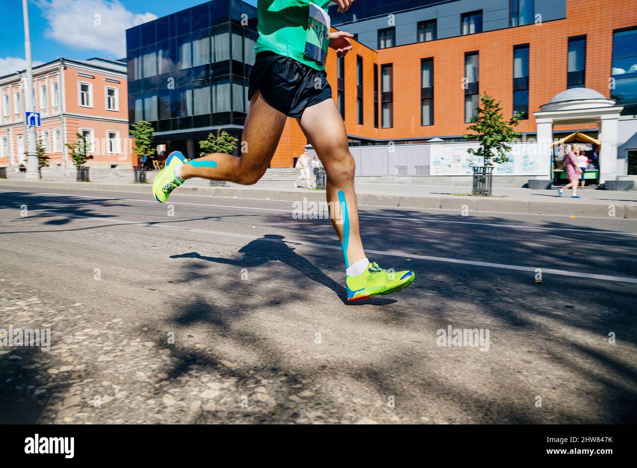 legs runner athlete with kinesio tape run in street of city Stock Photo ...