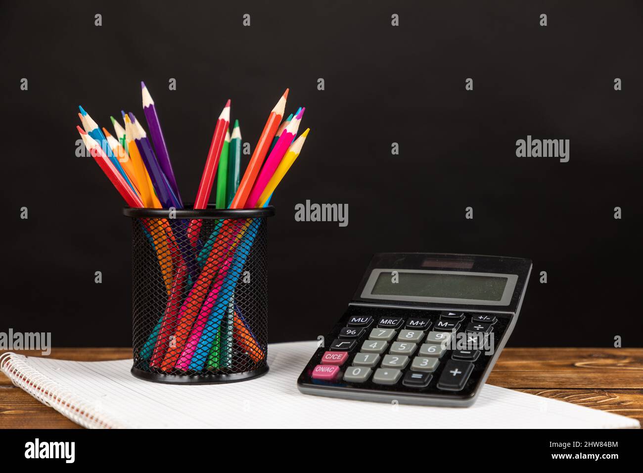 Stack of colored pencils with calculator and chalkboard Stock Photo - Alamy