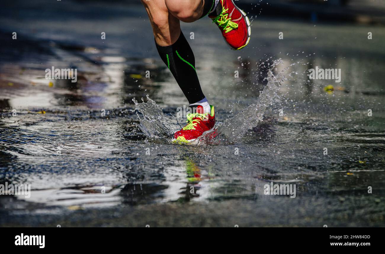 runner legs in compression socks run a puddle, splashing water Stock ...