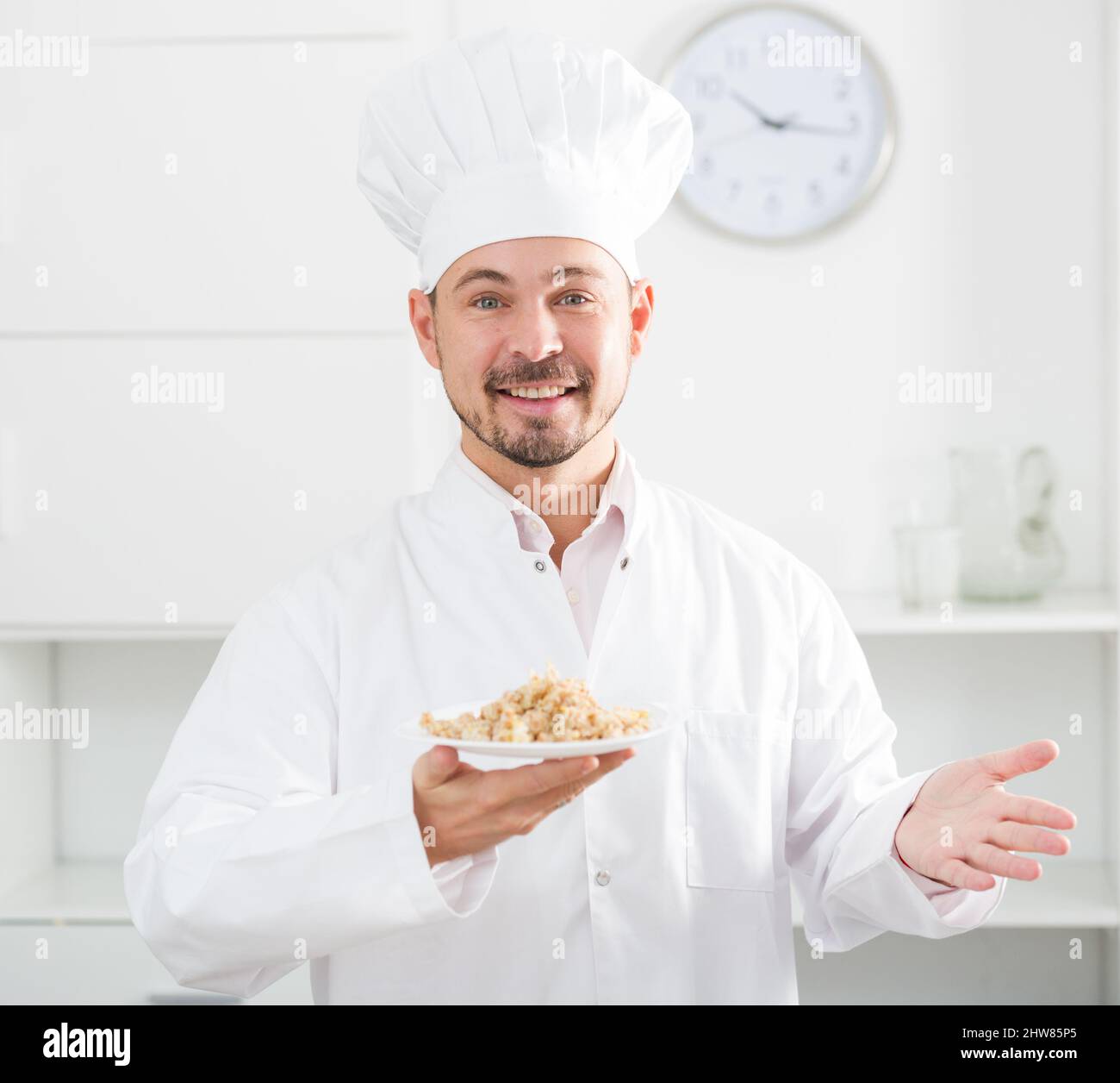 Positive cook with porridge Stock Photo - Alamy