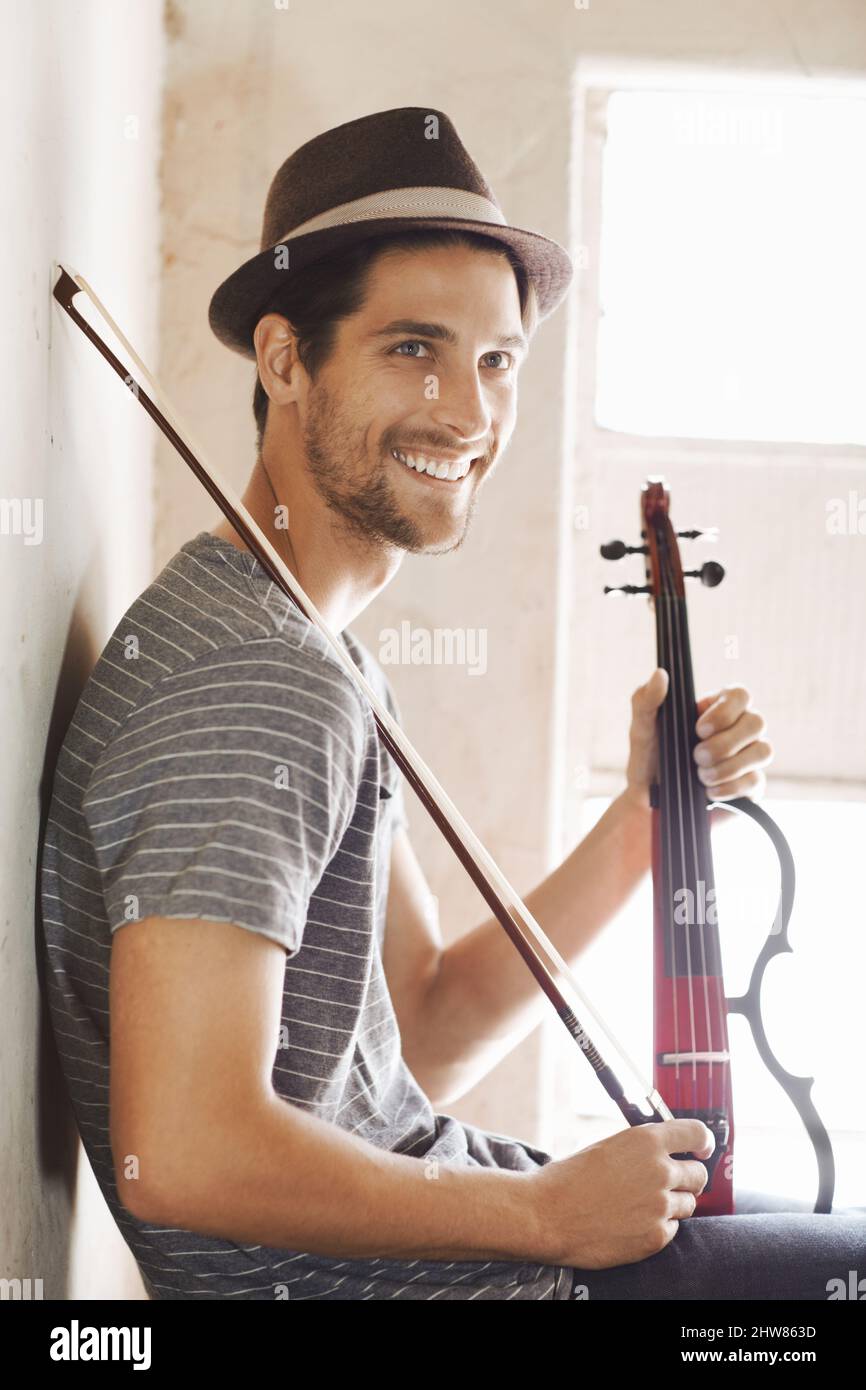 Ready to make some music. Handsome young musician holding his violin on ...