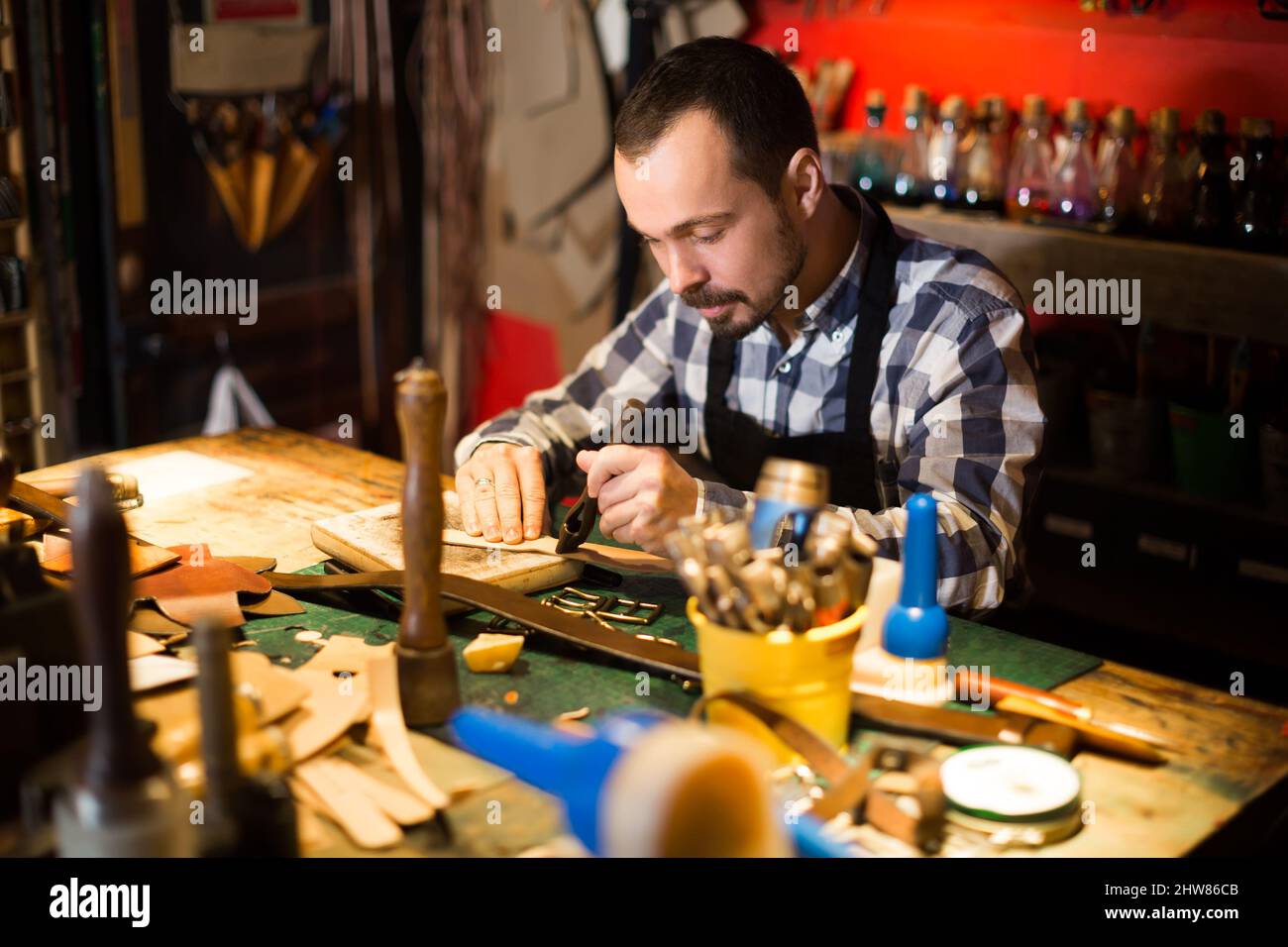 Professional man worker working in leather workshop Stock Photo - Alamy