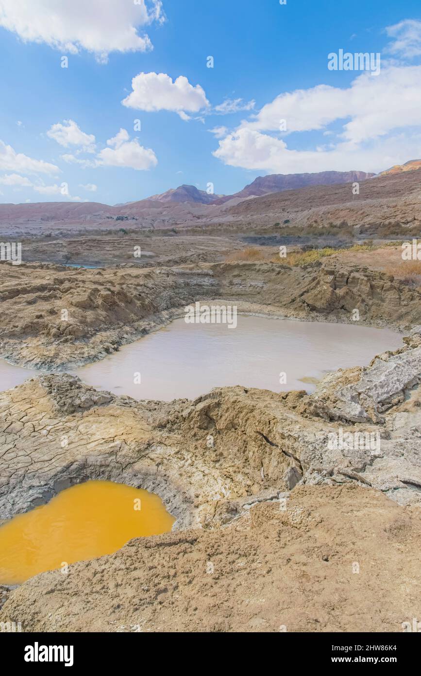 Sinkhole filled with water in different colors, near Dead Sea coastline ...