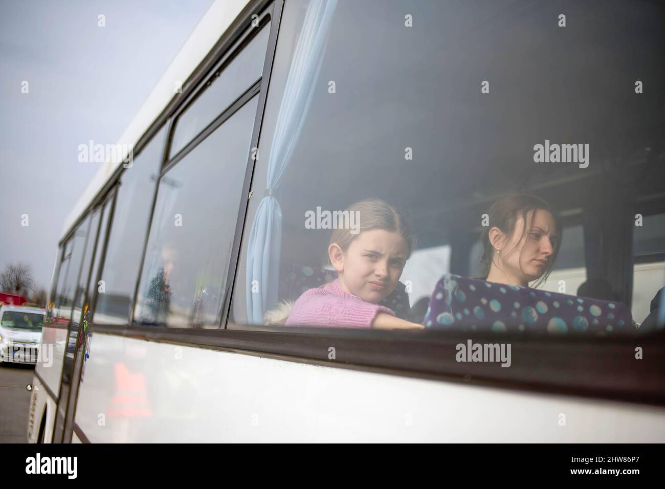 A girl looks out through the window of a coach that arrived from ...
