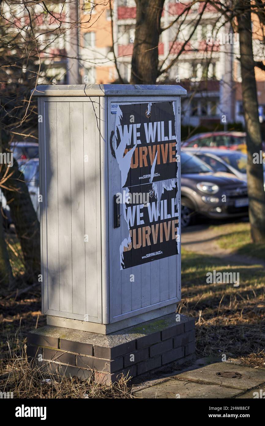 Vertical shot of the electricity box with a We Will Survive banner by a ...