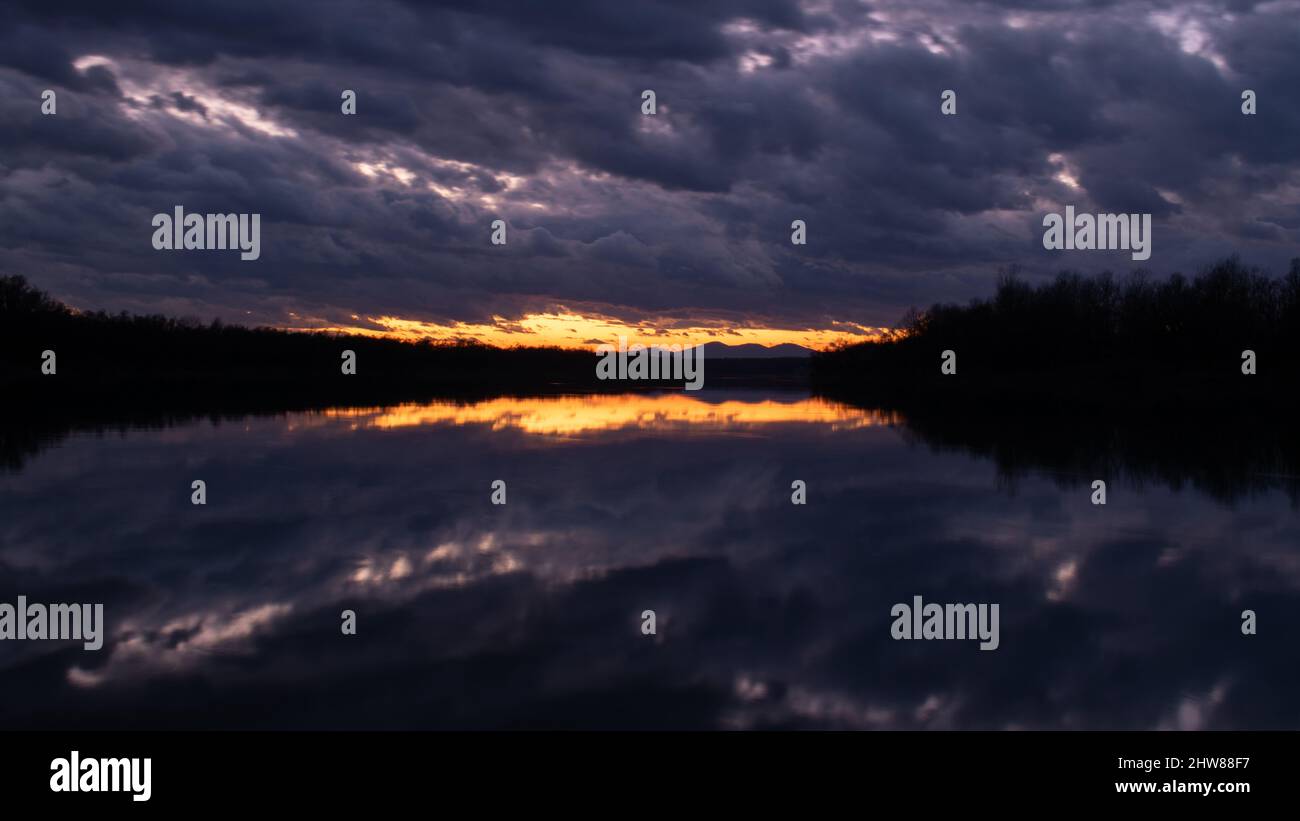 Twilight landscape with dark ominous storm clouds and fading orange ...