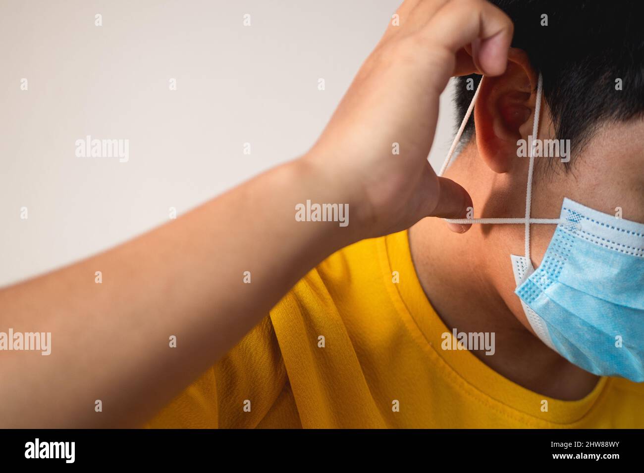 Twisting of medical mask’s straps. This method helps to improve the fit ...