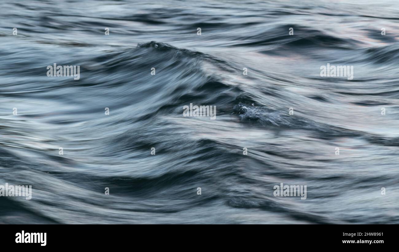 Abstract landscape of wavy turbulent water in wind with silky surface ...
