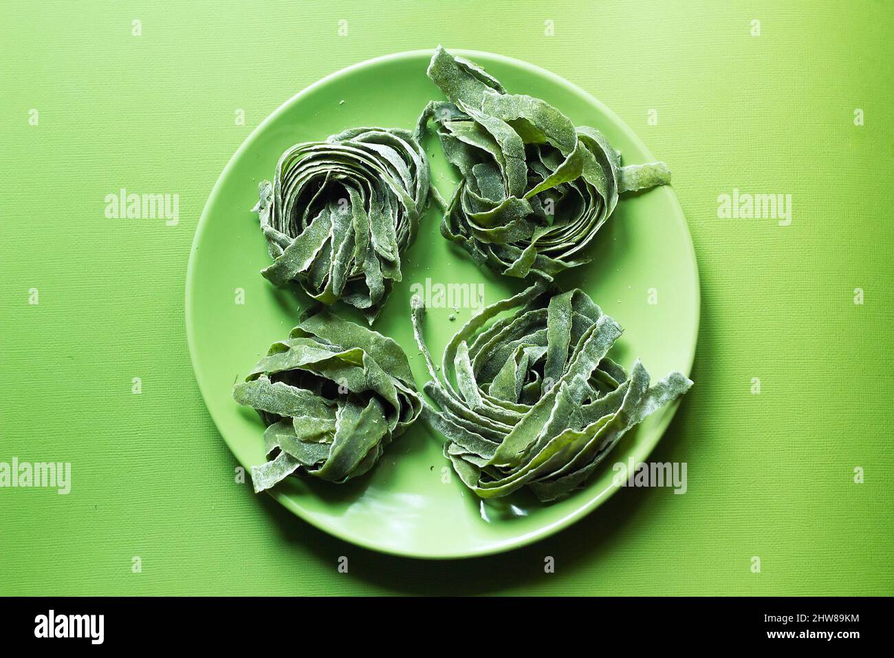 Four servings of stinging nettle fettuccine on a plate prepared for ...