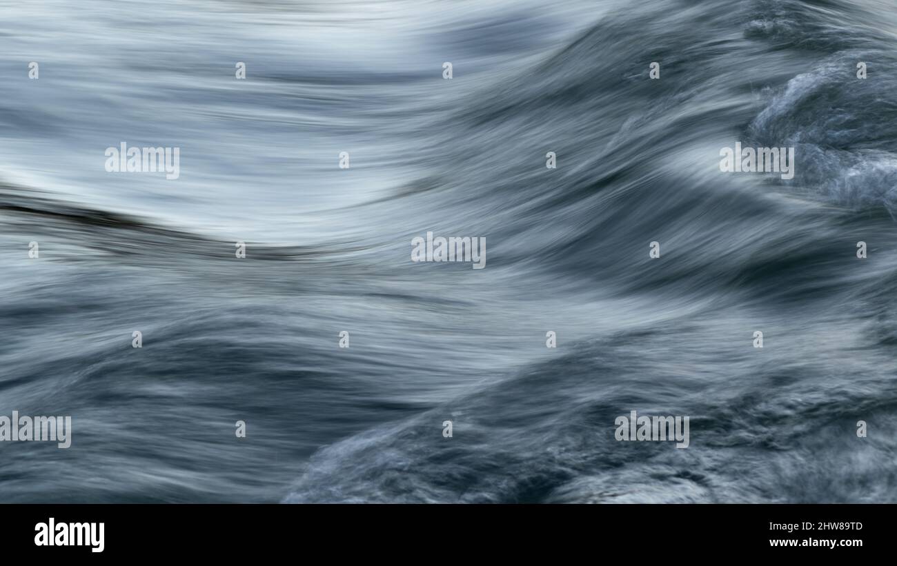 Rapid water flow in mountain stream with silky surface and motion blur ...