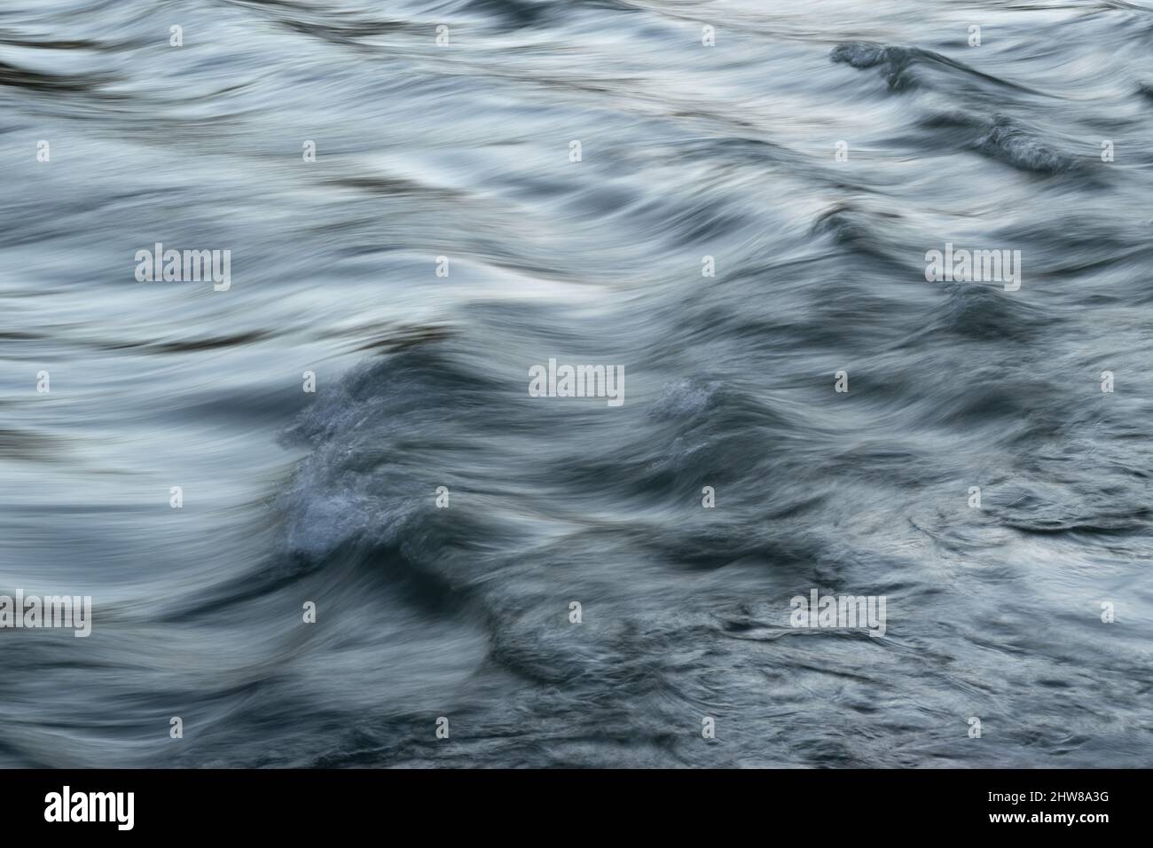 Rapid water flow in mountain stream with silky surface and motion blur ...
