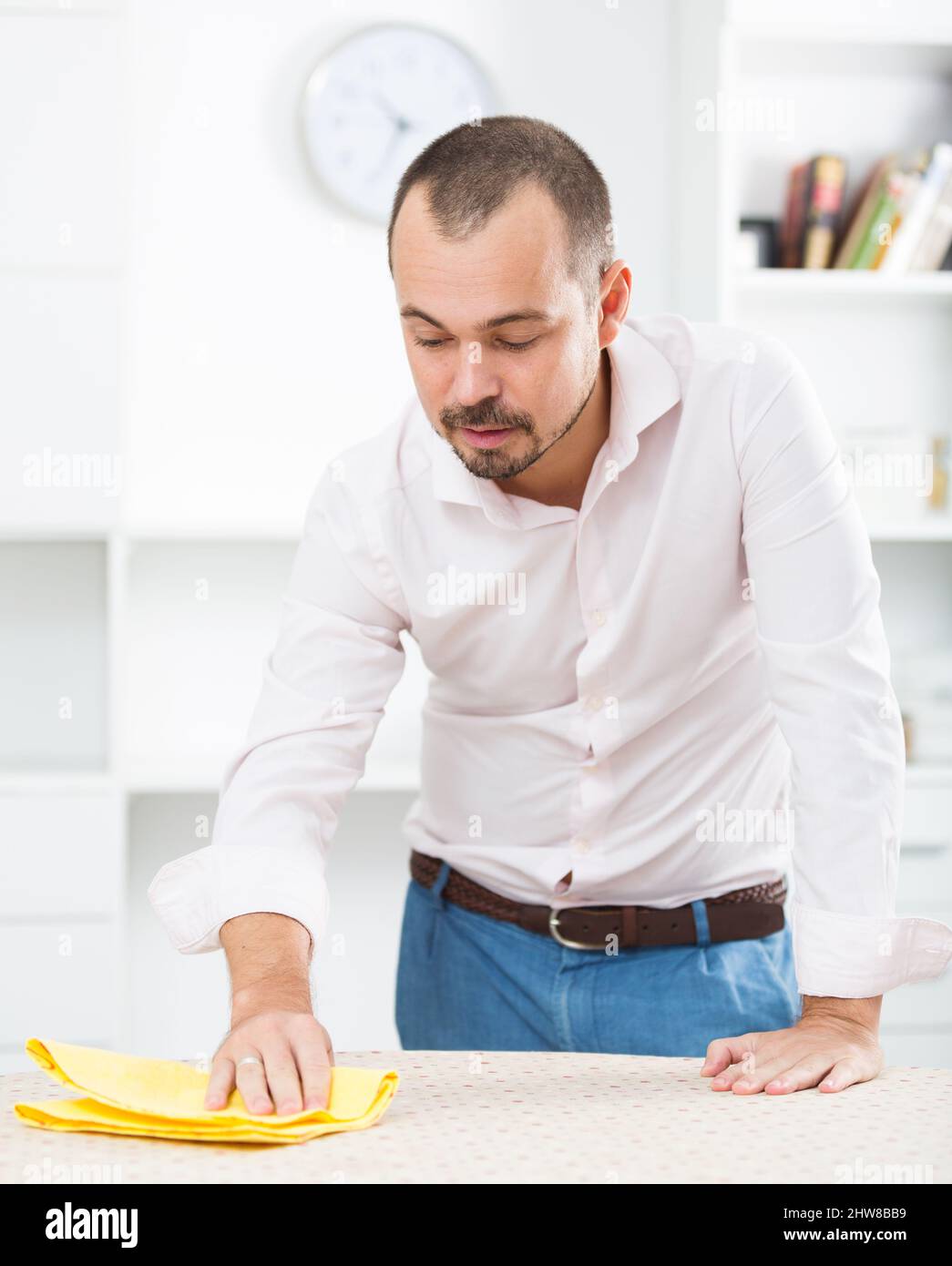 Positive young man cleaning office desk Stock Photo - Alamy