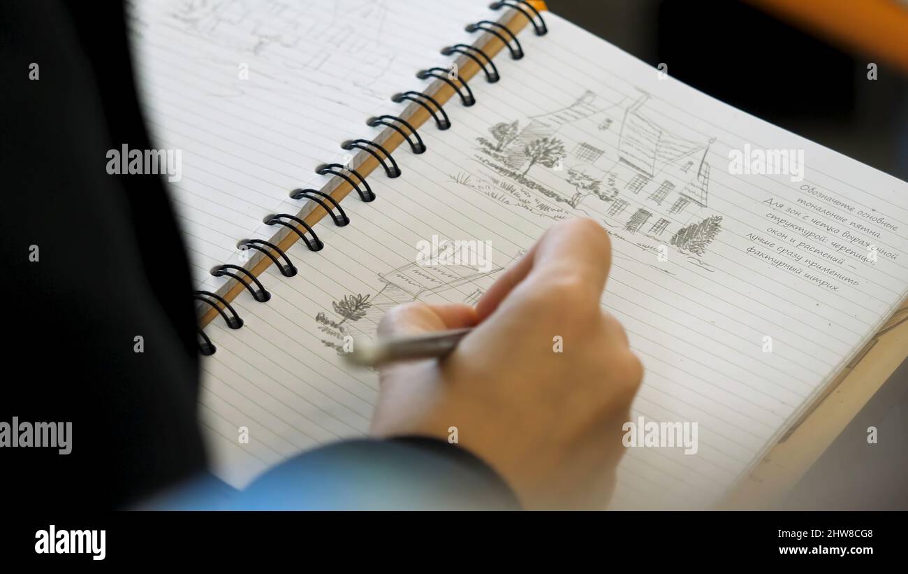 Hands holding pencil to write or to draw in a notebook. Adult colouring ...