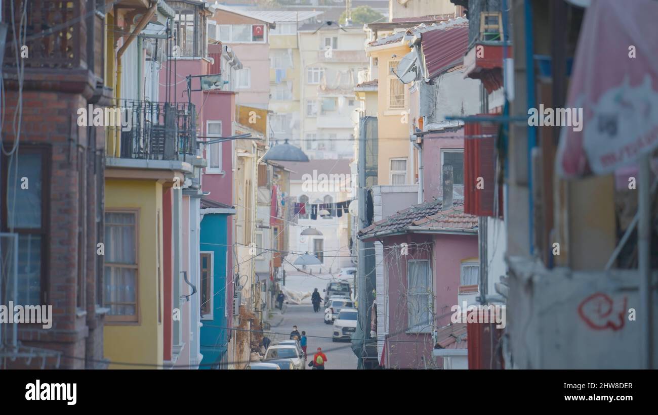Narrow street with colorful houses and people walking. Action. Busy ...