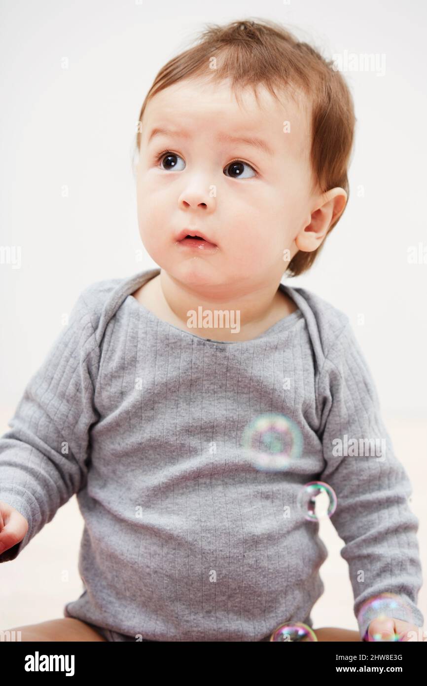 Full of wonder. Shot of an adorable baby boy looking at bubbles ...