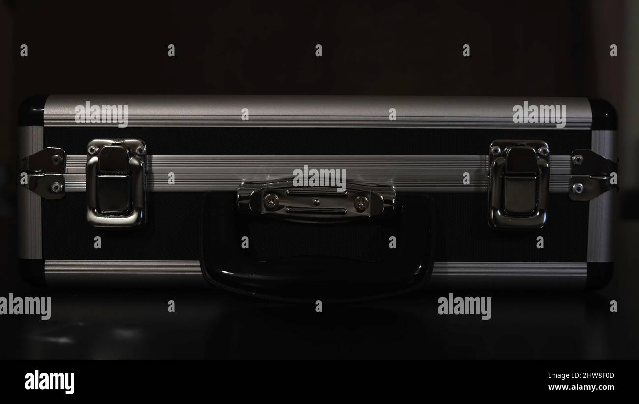 A person finding treasure in silver metal suitcase in a dark room ...