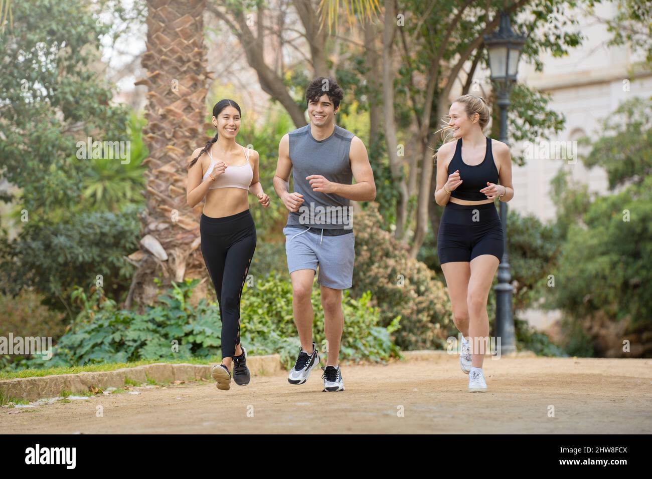 Young people doing sports at the park. They are running and smiling ...