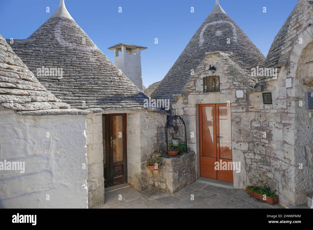 Sunny impression of trulli houses at a town named Alberobello in Apulia ...