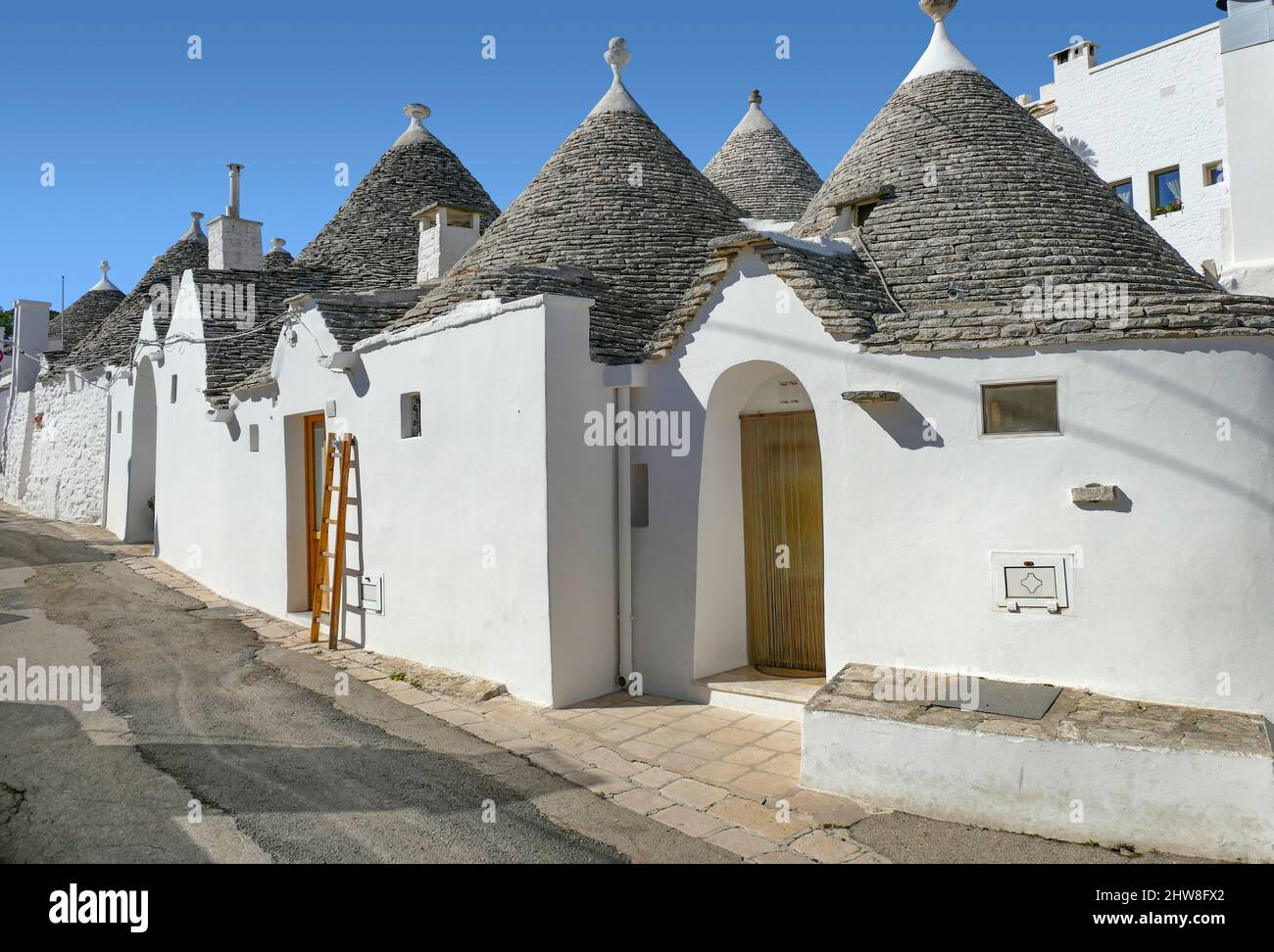 Sunny impression of trulli houses at a town named Alberobello in Apulia ...