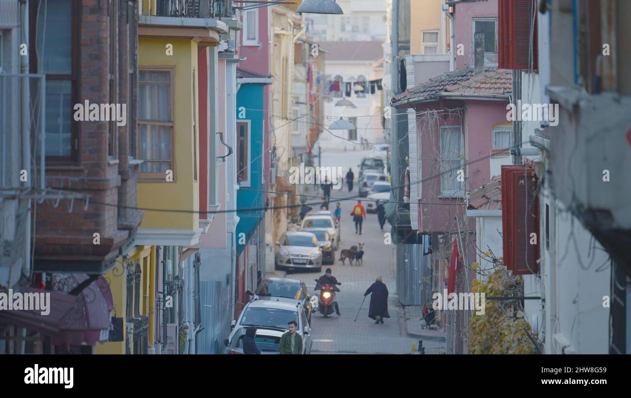 Narrow street with colorful houses and people walking. Action. Busy ...