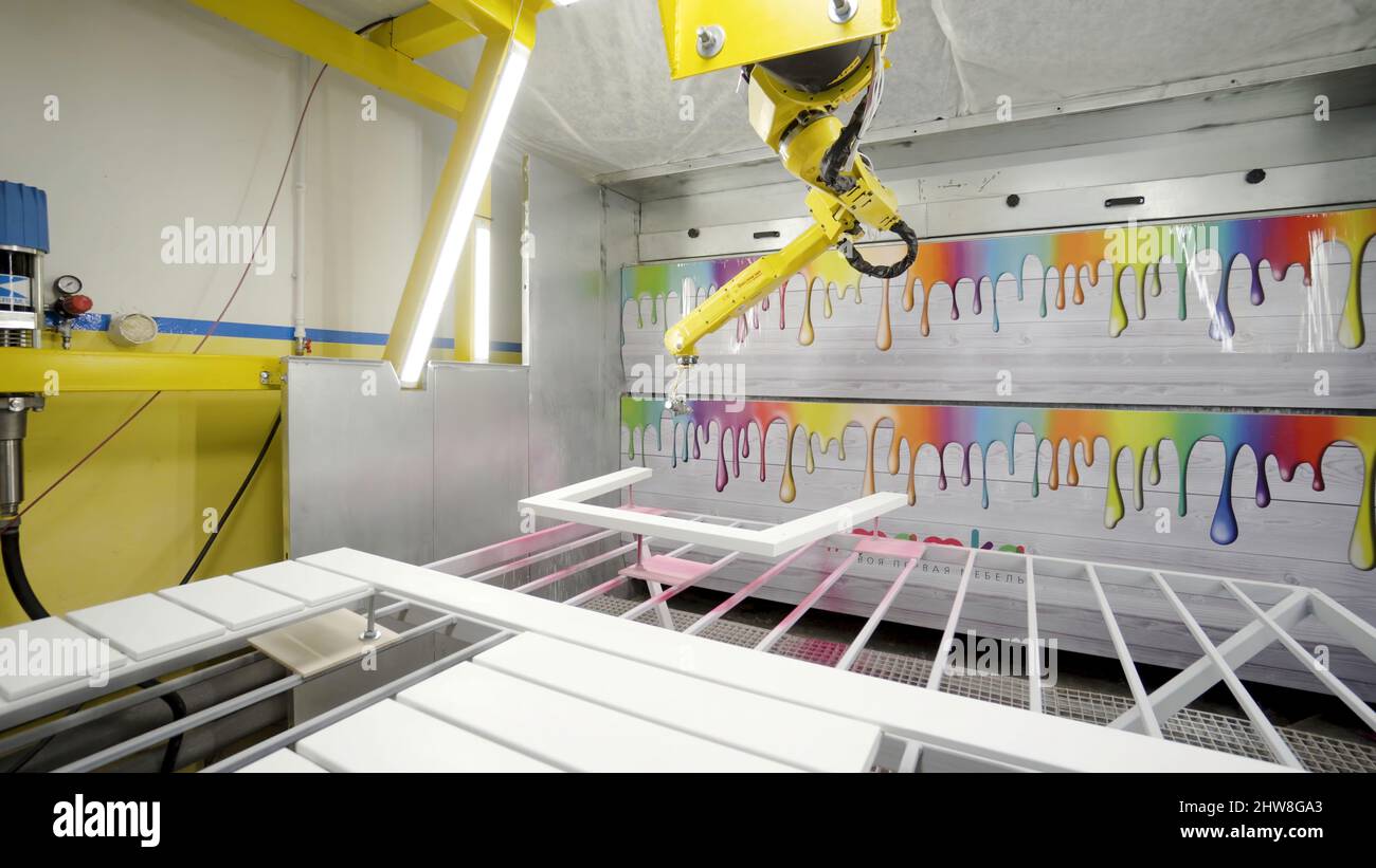 Industrial robotic arm paints frame. Action. Modern equipment for ...
