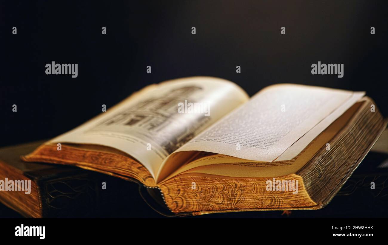 Open old book lying on the table with pages turning by wind. Vintage ...