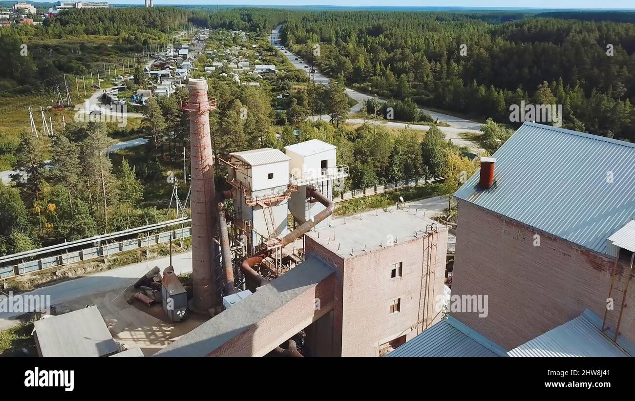Factory with brick chimney on background of village. Stock footage. Top ...