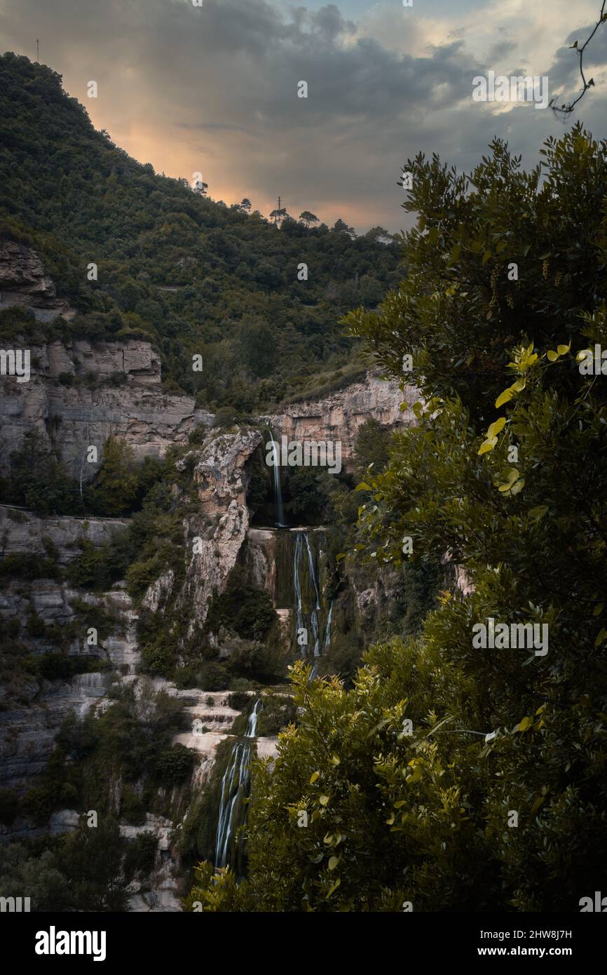 A waterfall on a green mountain full of trees Stock Photo - Alamy