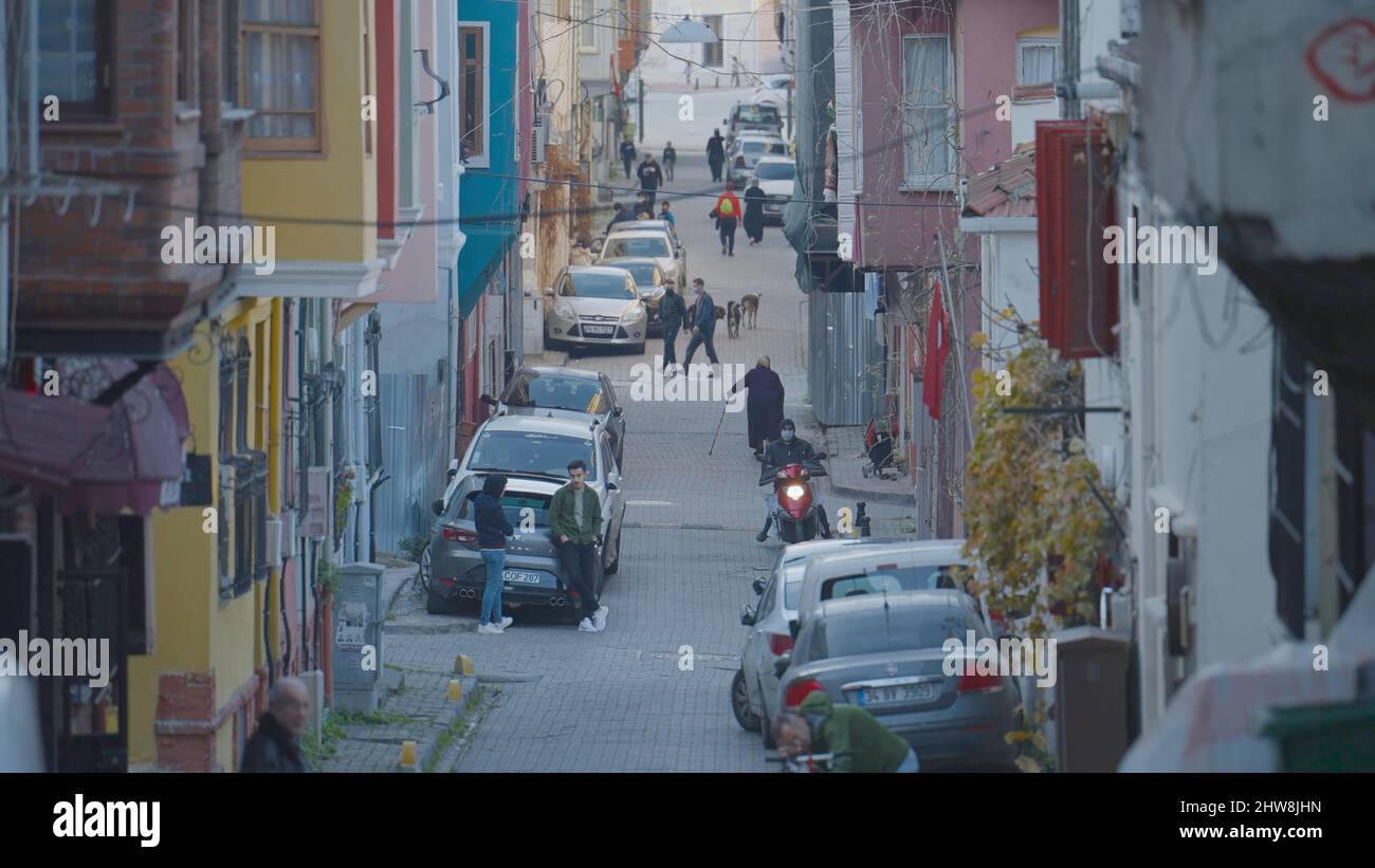 Narrow street with colorful houses and people walking. Action. Busy ...