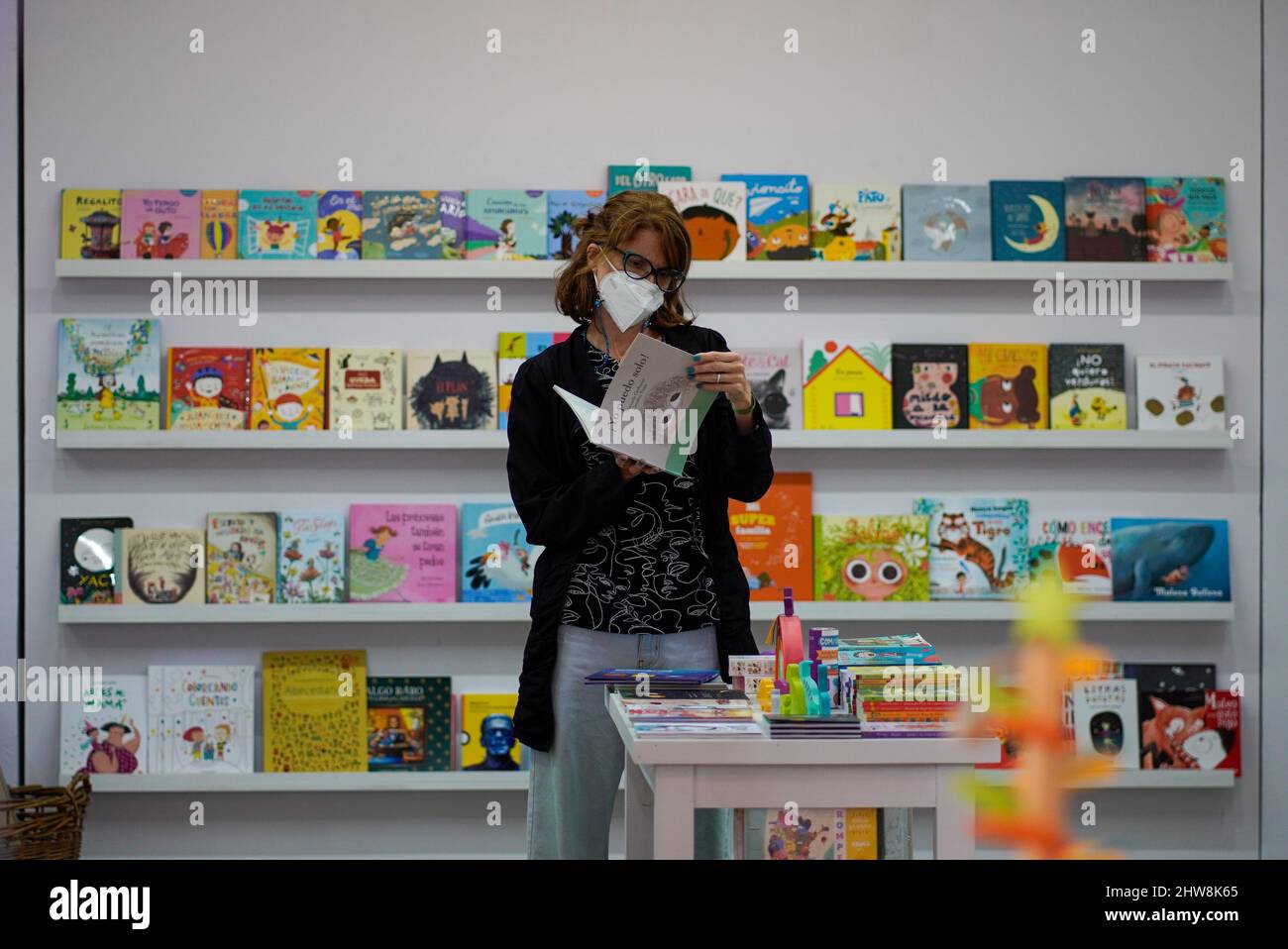 Woman reading a book inside a children's bookstore Stock Photo - Alamy