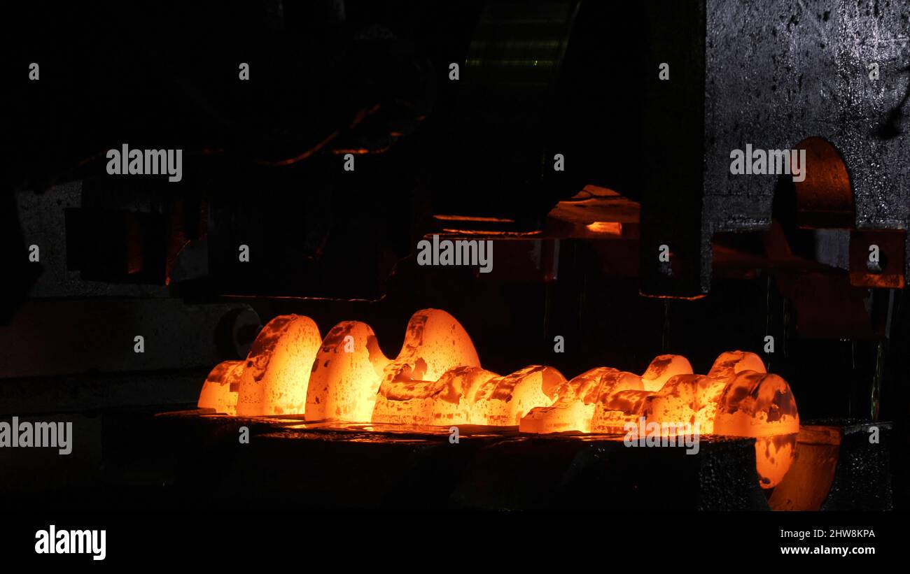 Close up view of hot steel forging process with big mechanical hammer ...