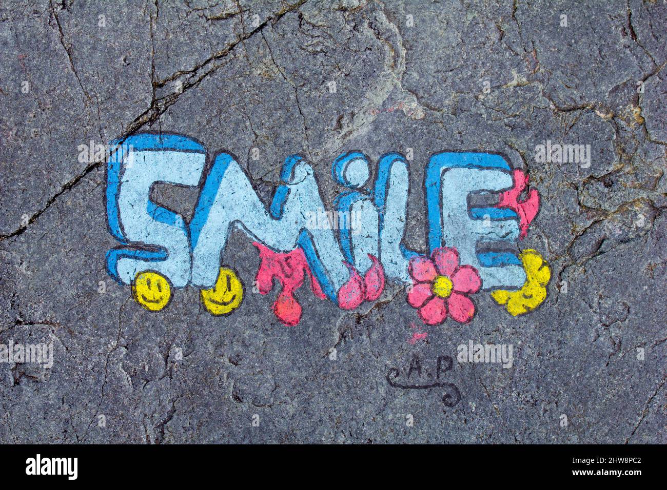 Chalk drawing of the word SMILE on a rock on Coverack beach, Cornwall ...