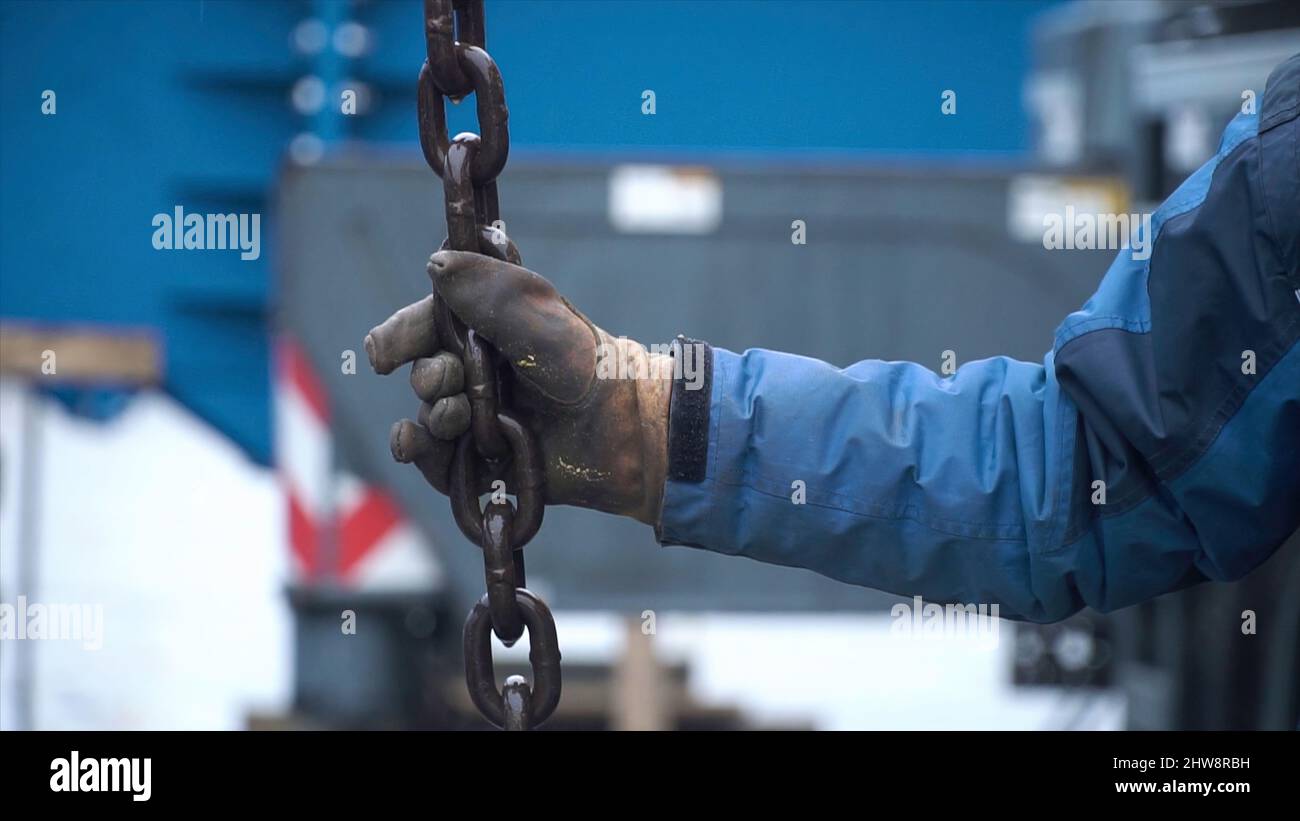 Worker touches the crane hooks to the loops during repair work. Clip ...