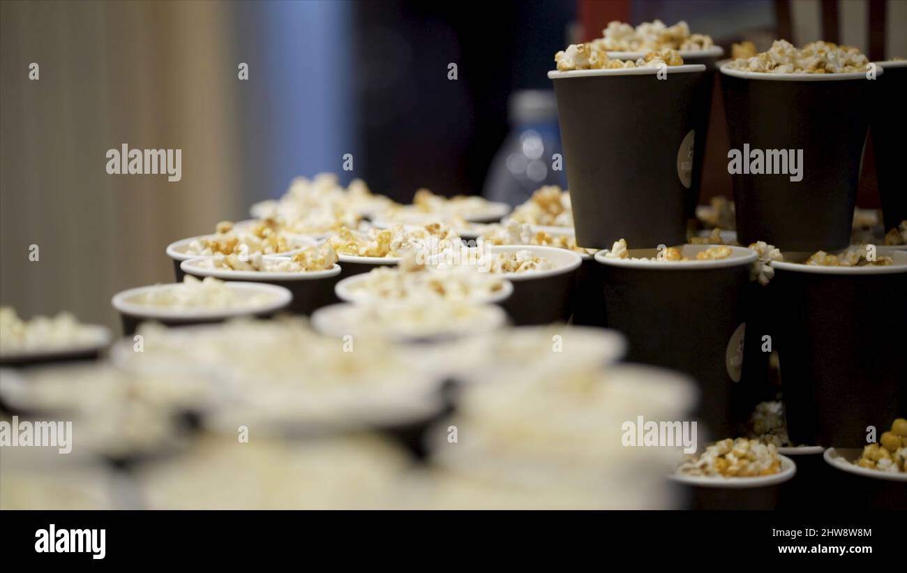 Many cups of popcorn in cinema. Action. Delicious fragrant fresh ...