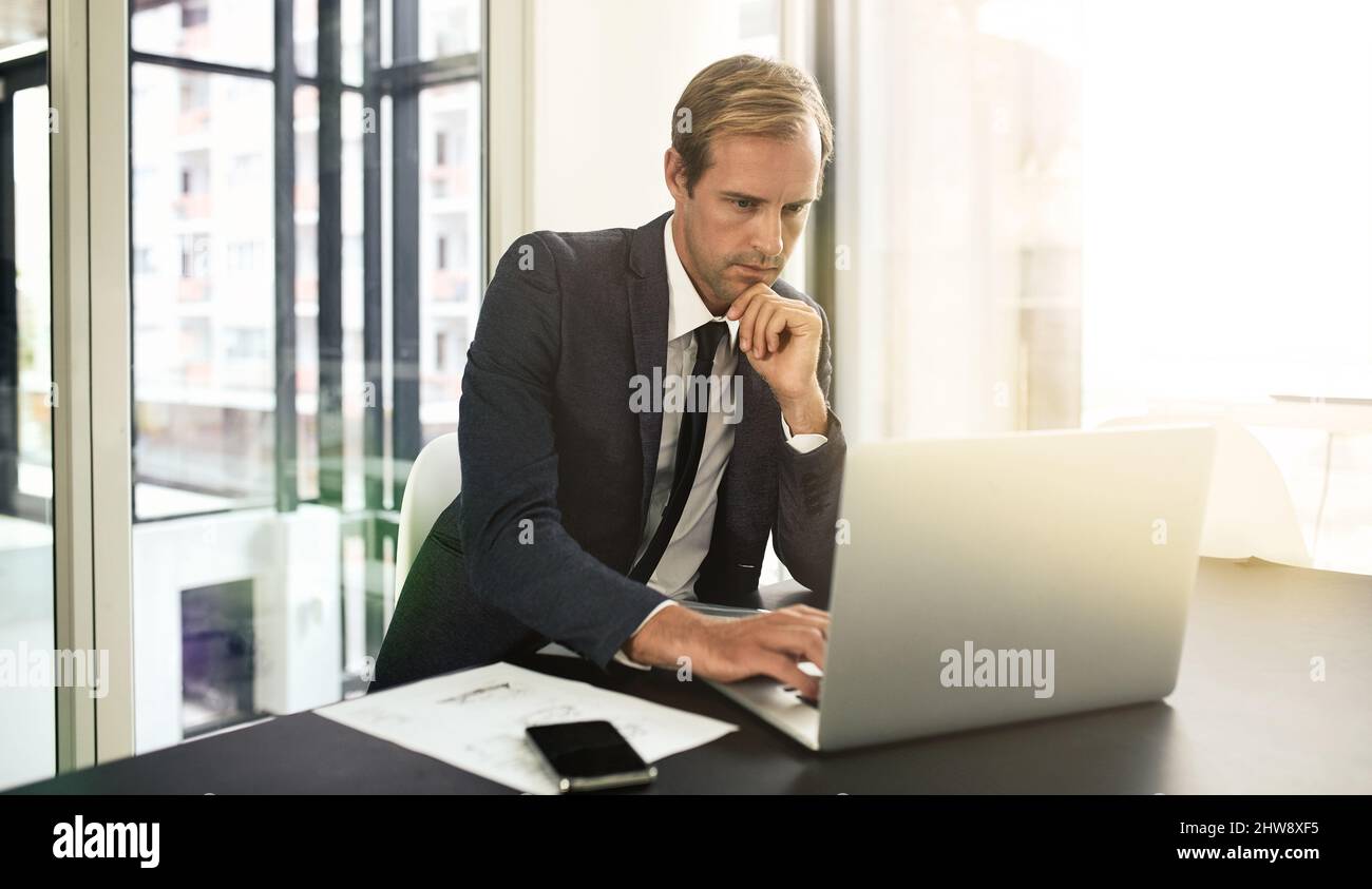 Focused on the task at hand. Shot of a businessman using his laptop ...