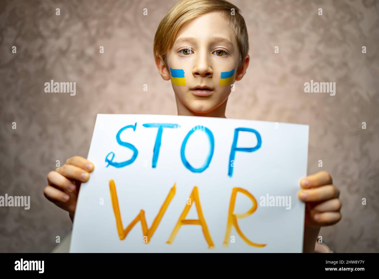 a child against war, a boy with a painted flag of Ukraine on his cheeks ...