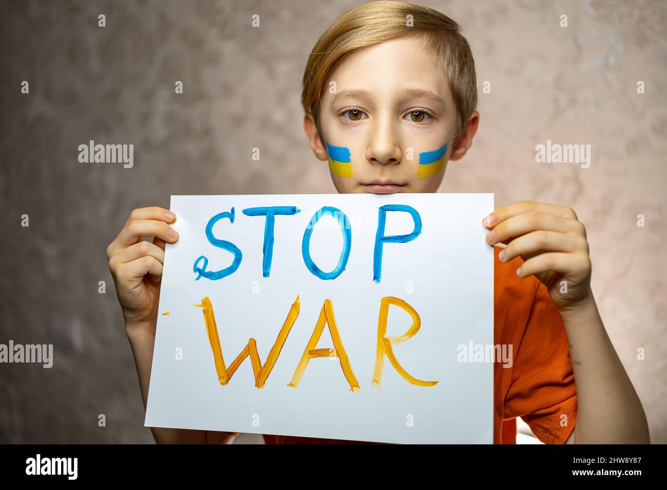 a child against war, a boy with a painted flag of Ukraine on his cheeks ...