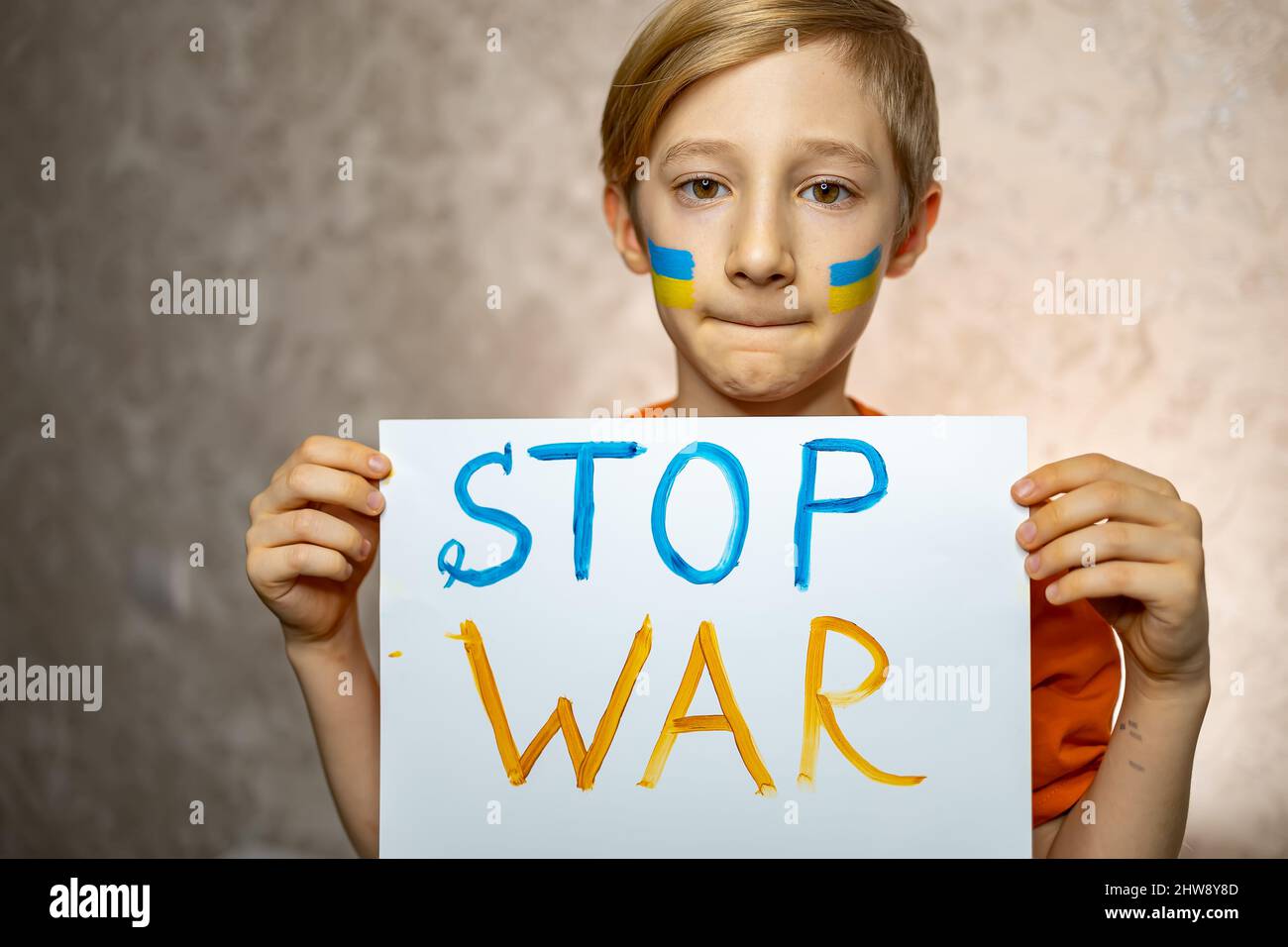 a child against war, a boy with a painted flag of Ukraine on his cheeks ...