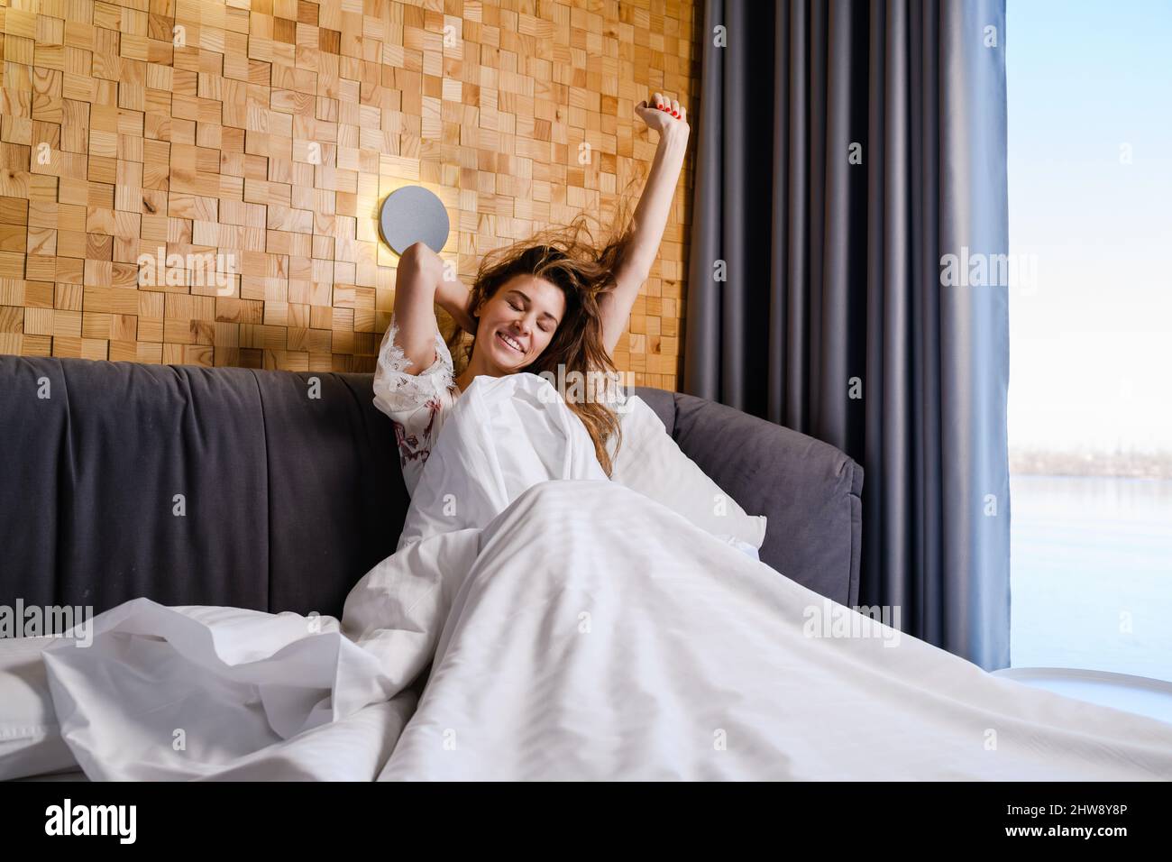 Young attractive girl wakes up in the morning in the bedroom. Girl ...