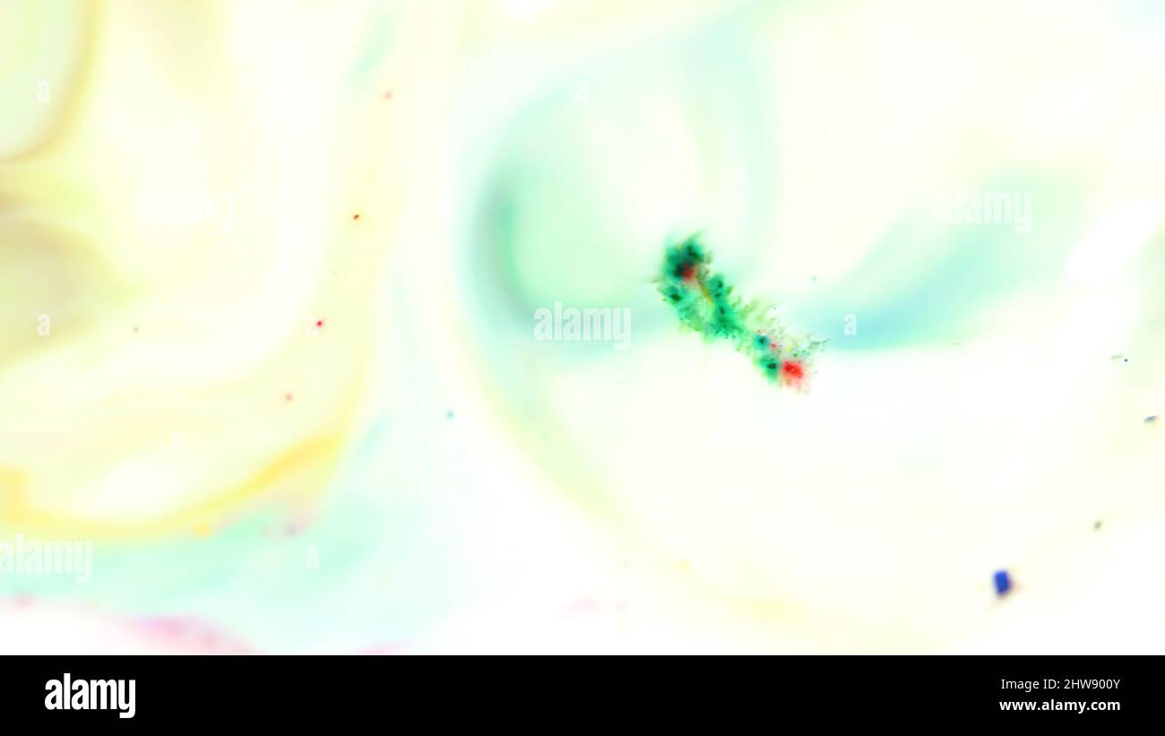 Colorful powder paint on milk. Close-up of powder paint floating moves ...