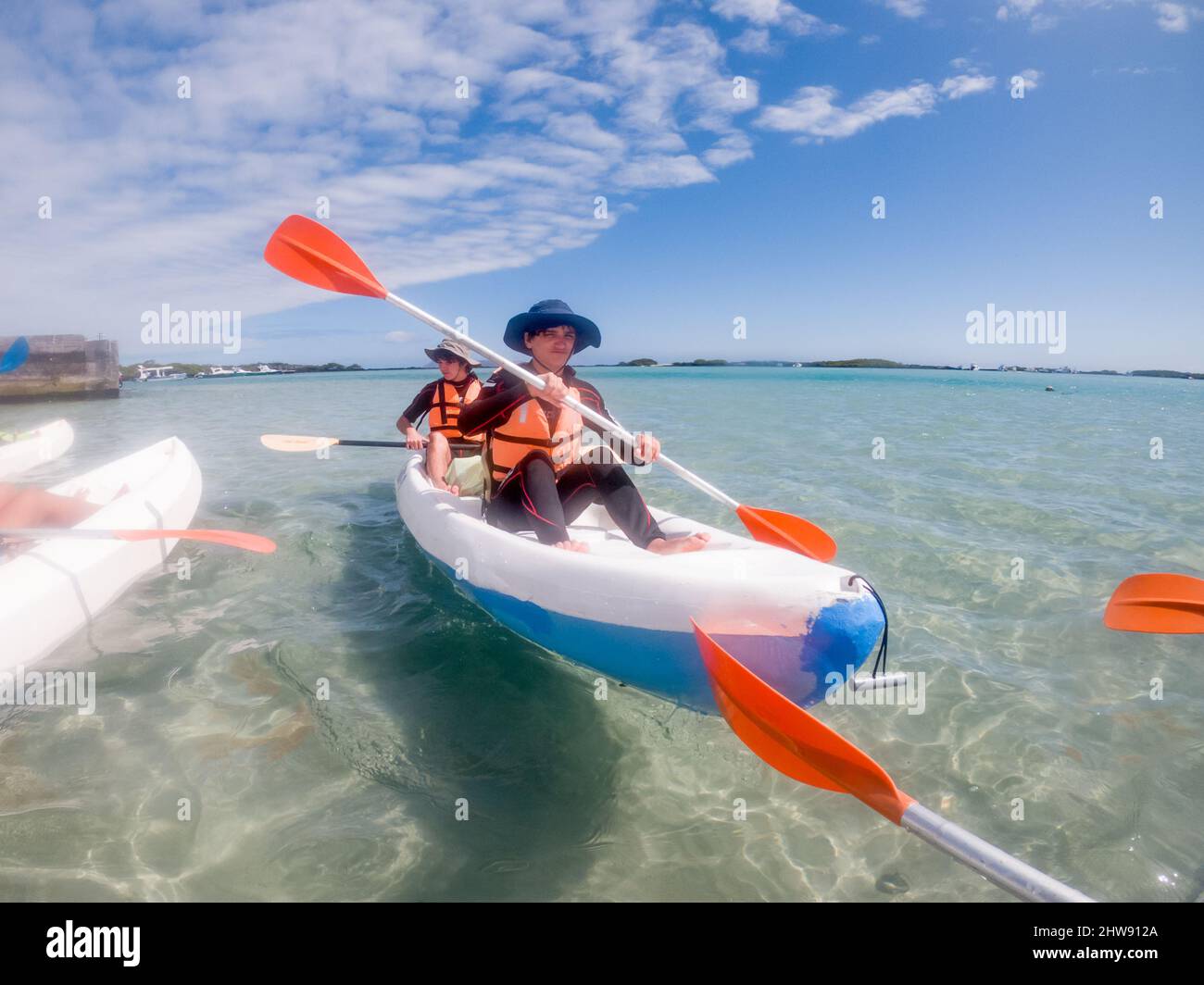 Teenagers kayaking in the ocean off of Isabela Isalnd, Galapagos ...