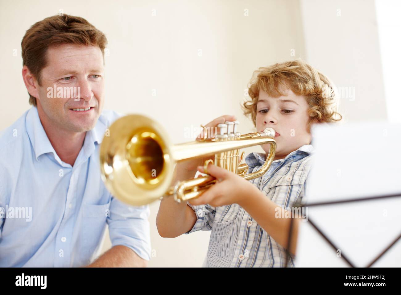 Proud of his little trumpet player. Shot of a cute little boy playing ...