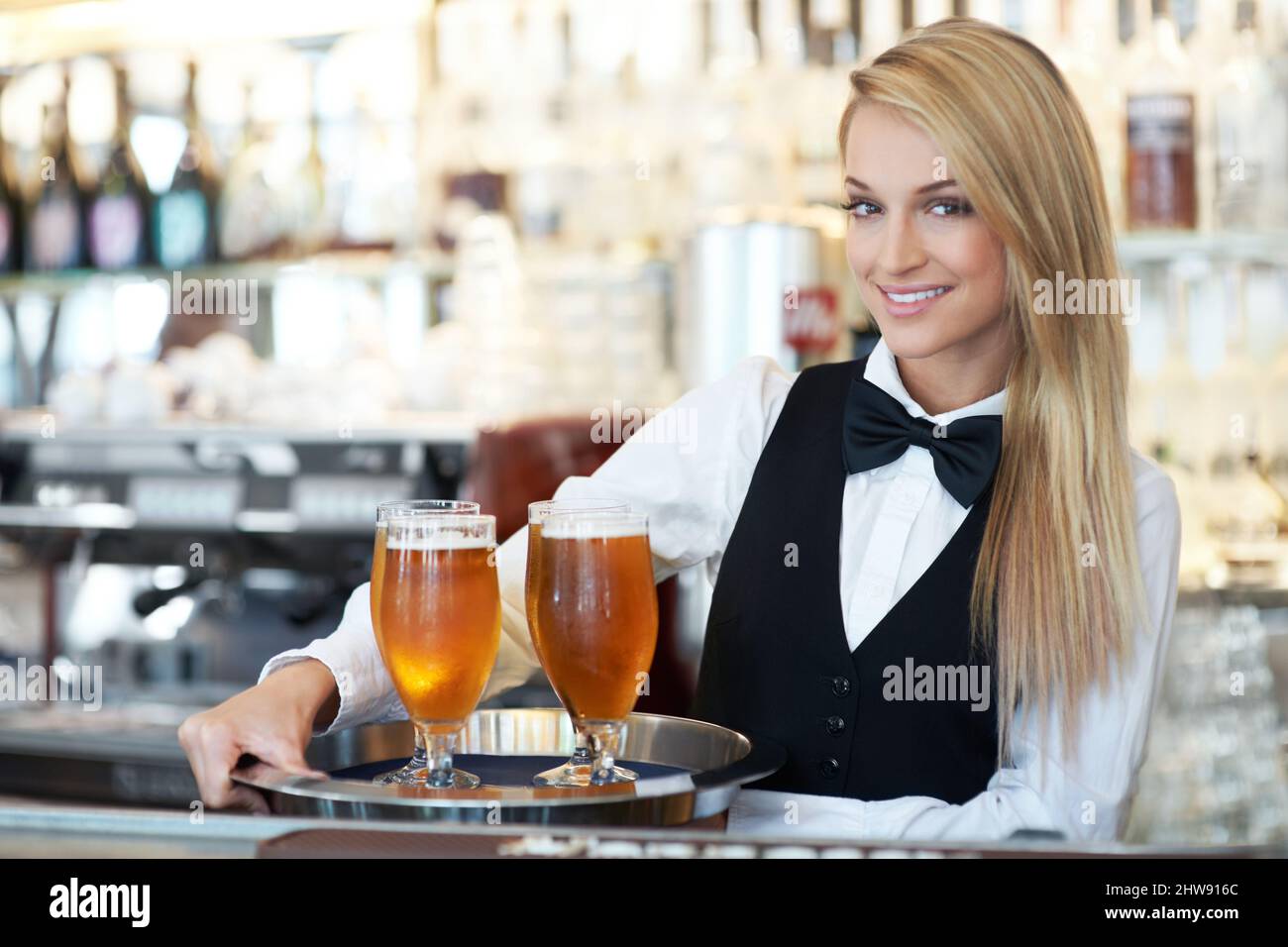 A great thirst for life. Portrait of a beautiful waitress collecting ...