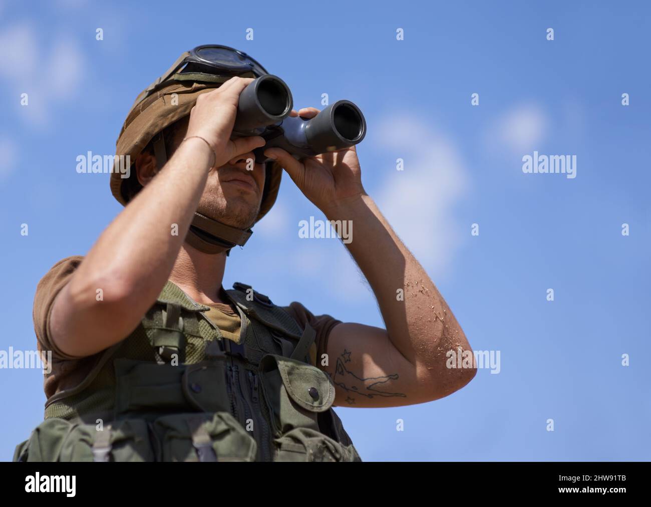 On the lookout. A young soldier looking through his binoculars Stock ...
