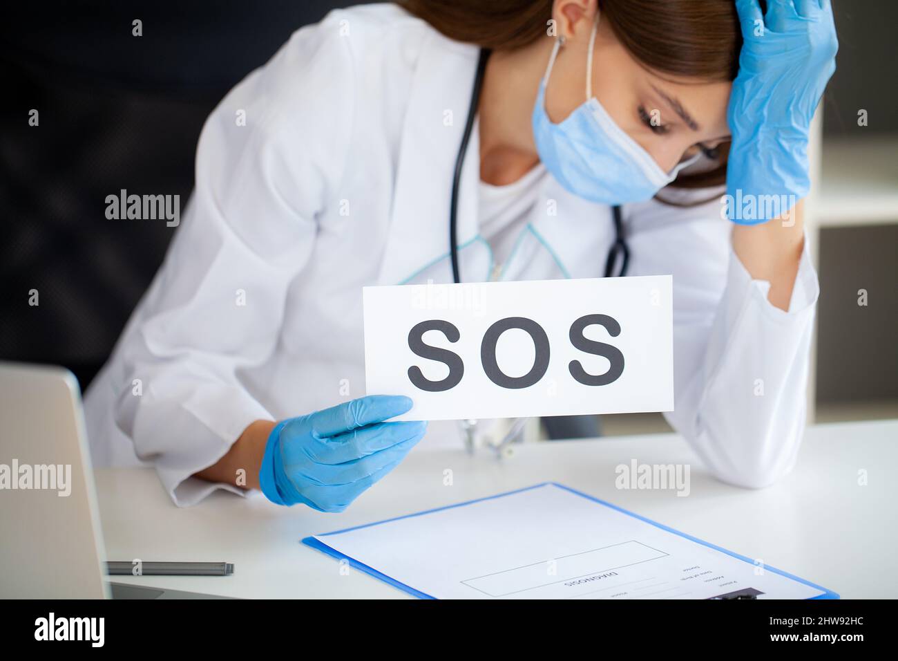 The doctor holds a form with the text sos Stock Photo - Alamy