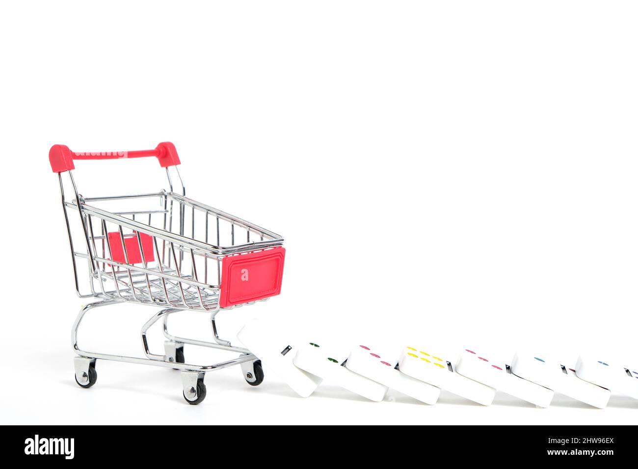Shopping cart and fallen dominoes white background Stock Photo - Alamy