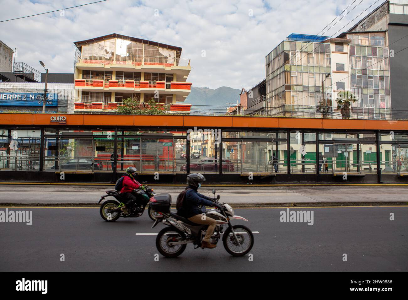 Motorcyclists pass buildings on street in Quito, Ecuador Stock Photo ...